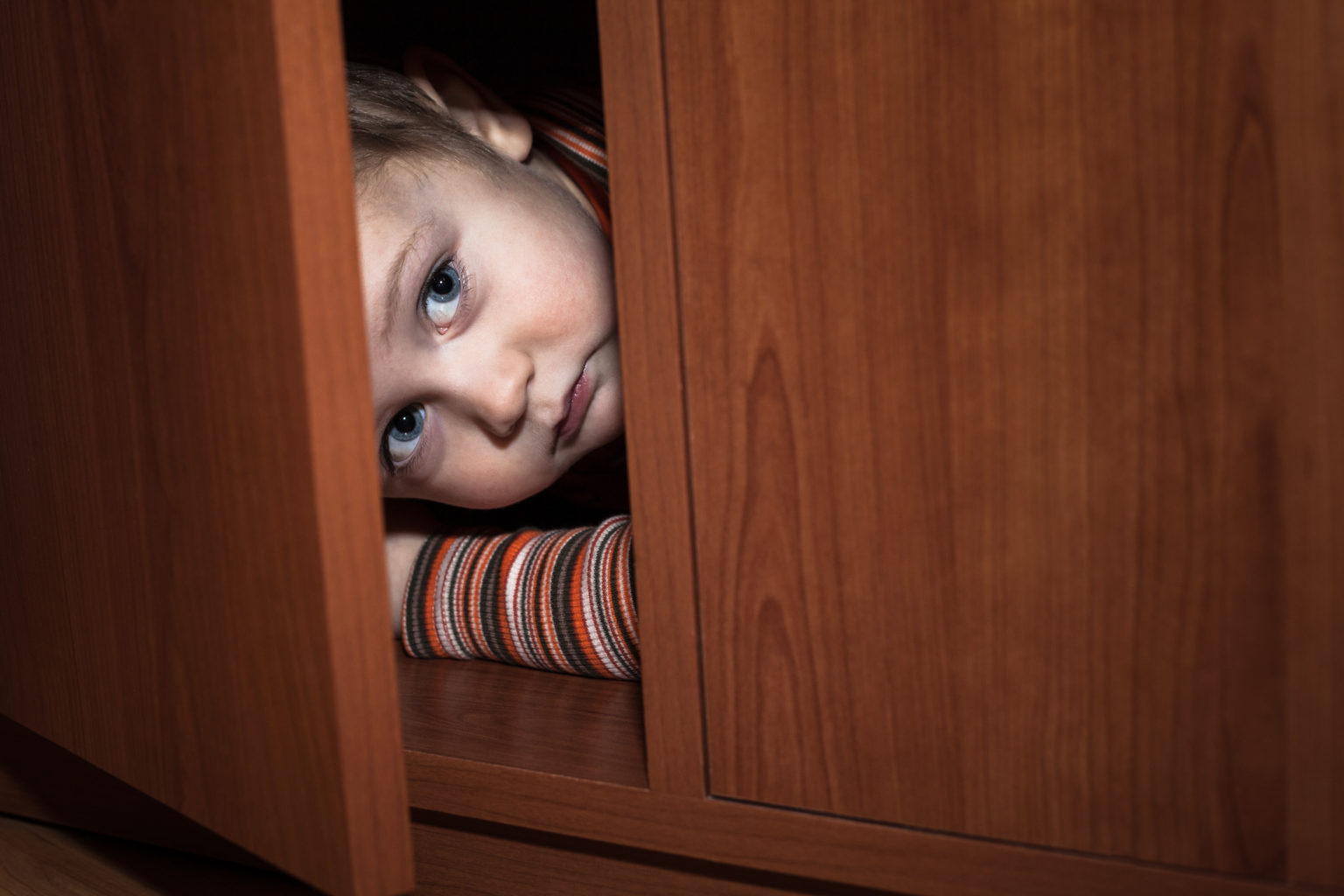 Scared child hiding - Observatório do 3° Setor
